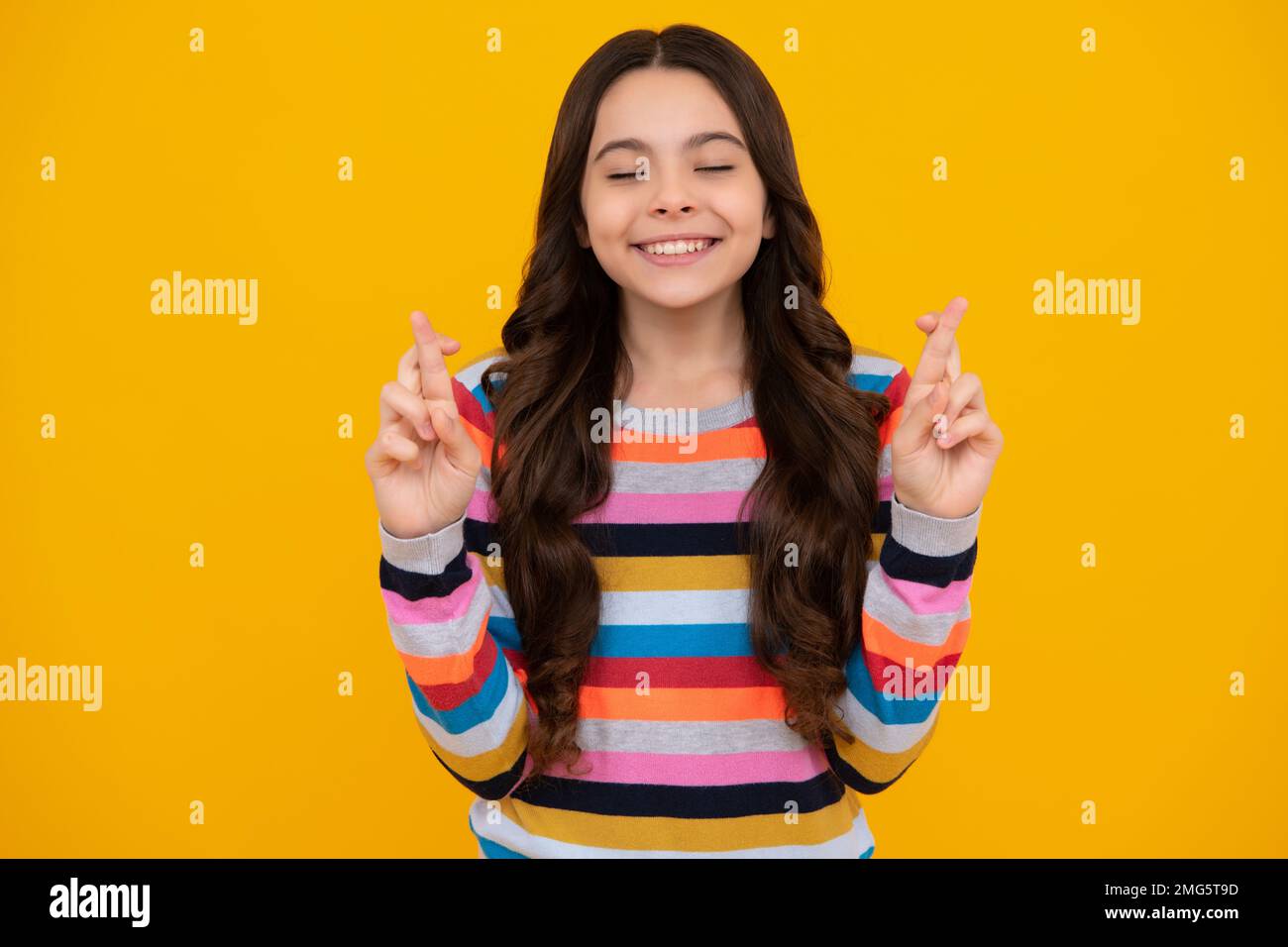 Teenager child holding fingers crossed for good luck. Portrait of ...