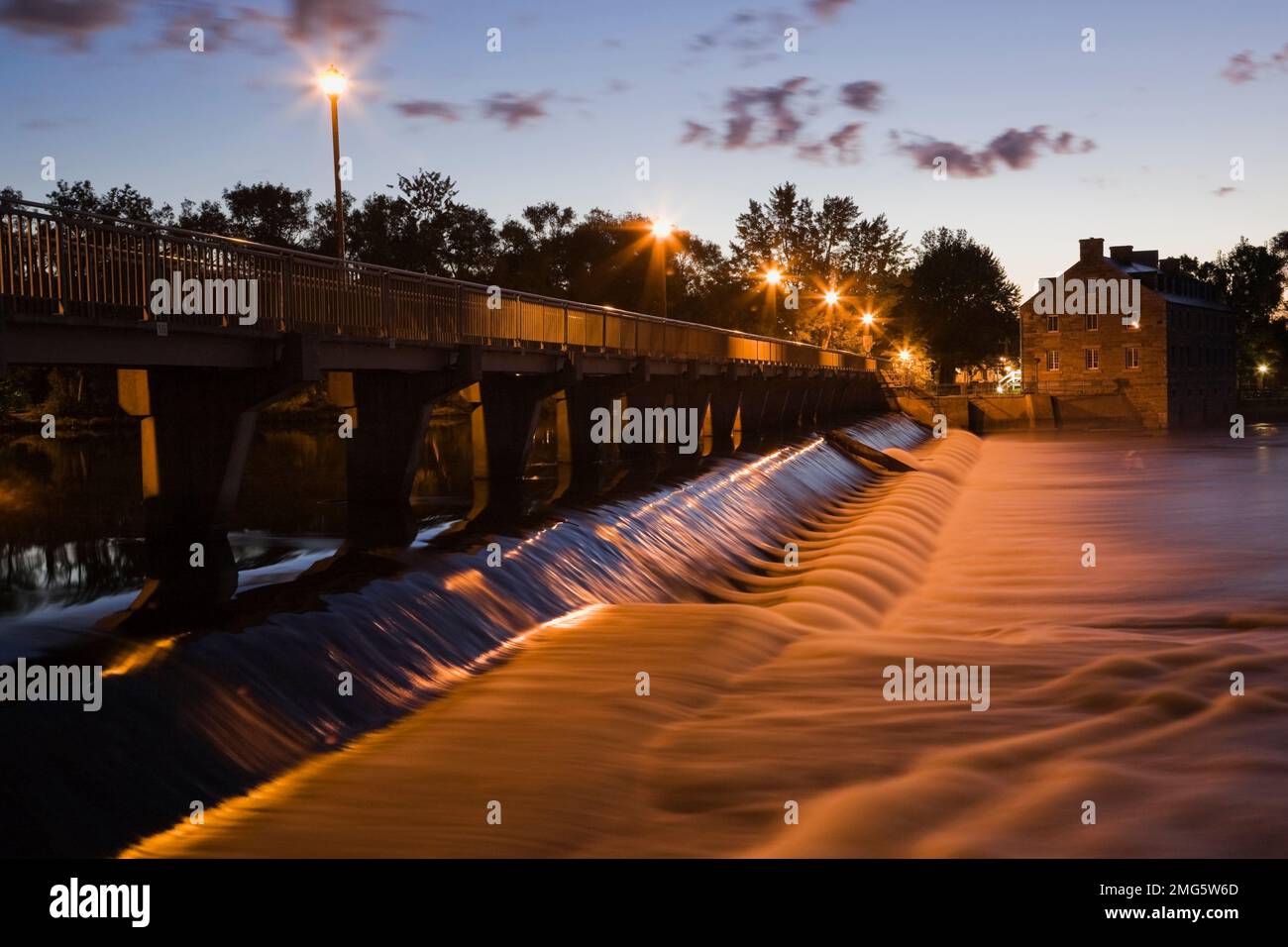 New Mill and water flow control dam on Mille-Iles river illuminated at ...