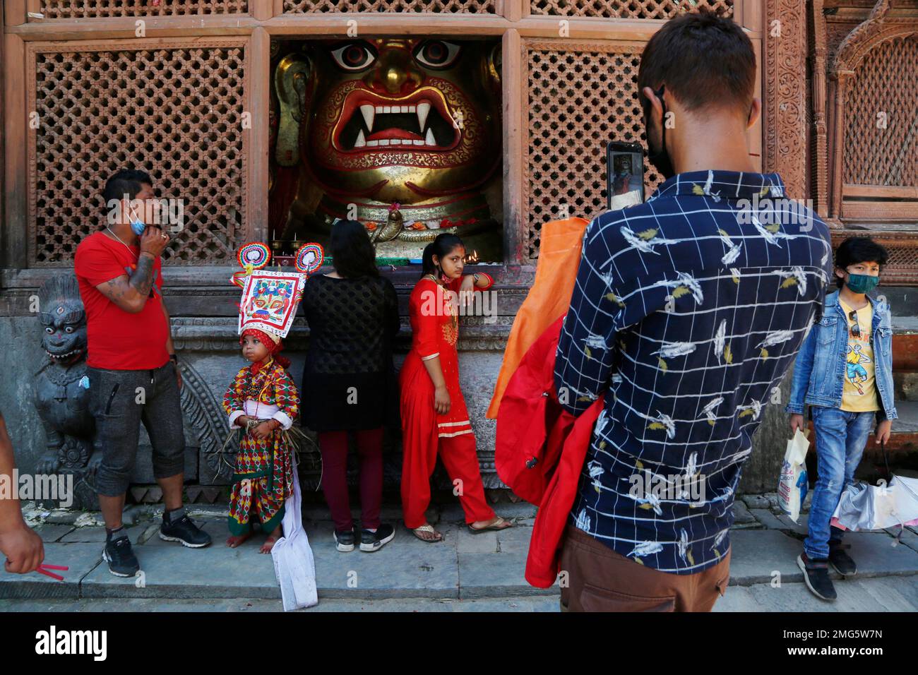 A Nepalese girl stands for a photograph in front of an idol of Swet ...