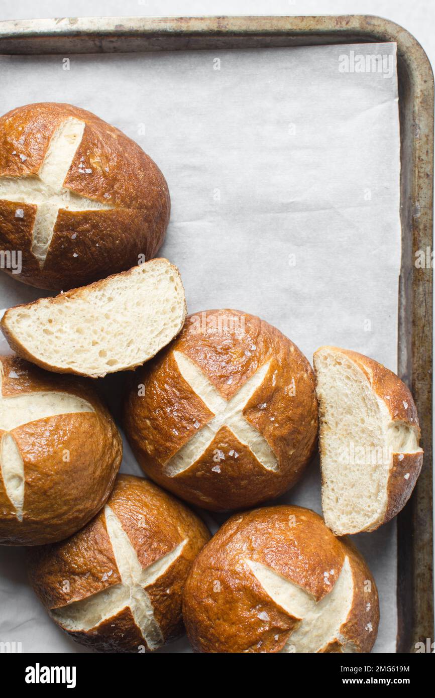 Top view of Pretzel buns on a parchment lined baking sheet, German ...