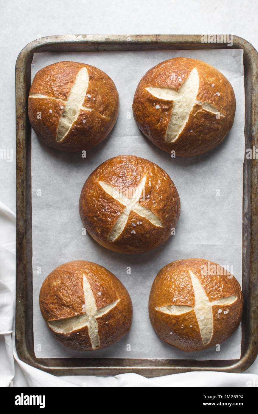 Top view of Pretzel buns on a parchment lined baking sheet, German ...