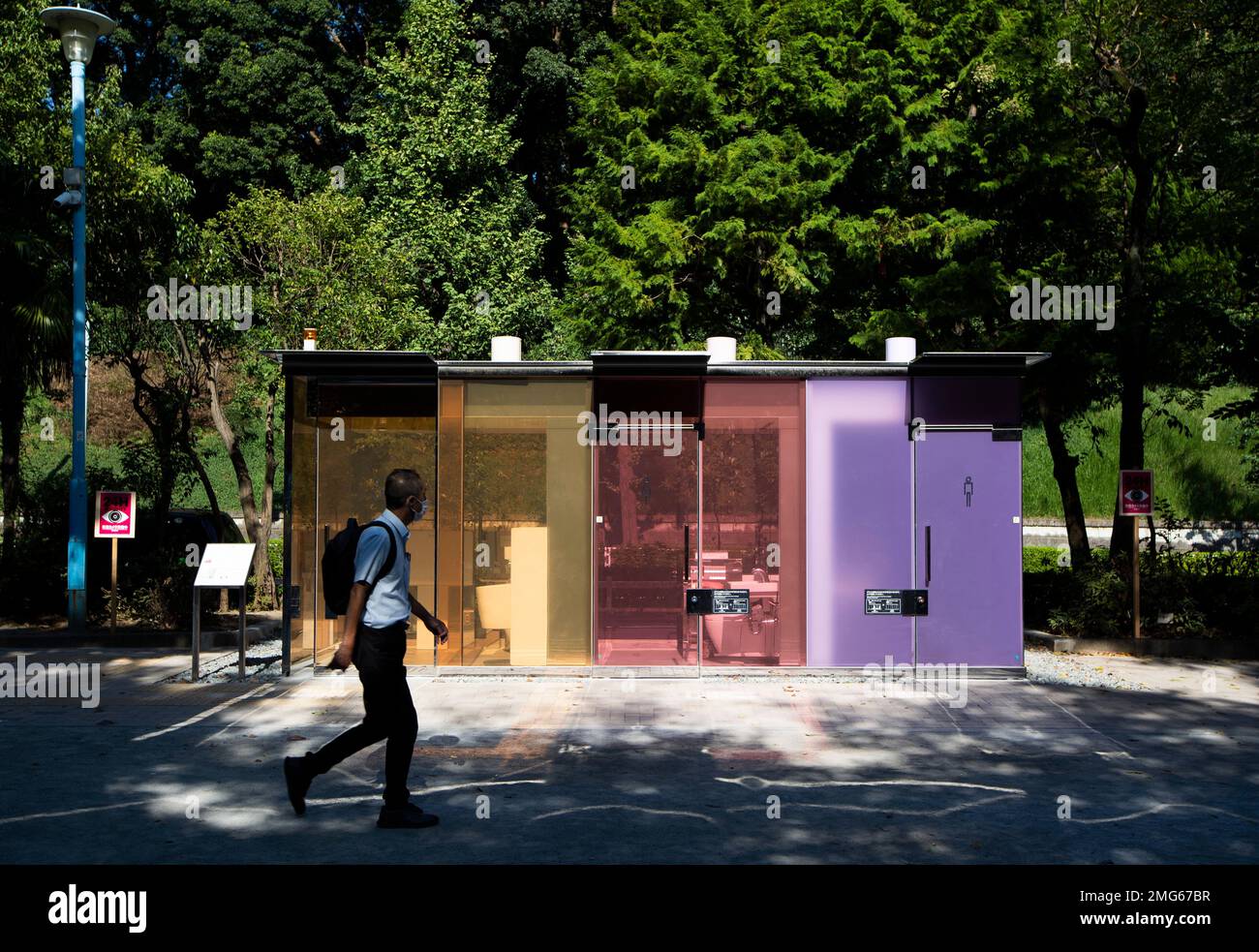 A man walks by the transparent glass toilets at Yoyogi Hukamachi Mini ...