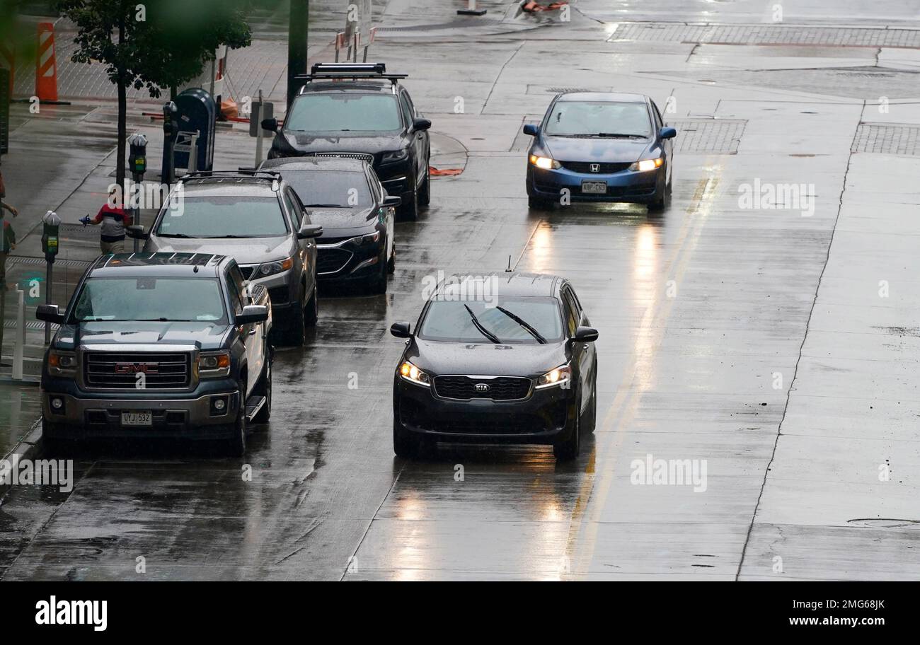 Motorists move along Wazee Street in a moderate rain as a late summer ...