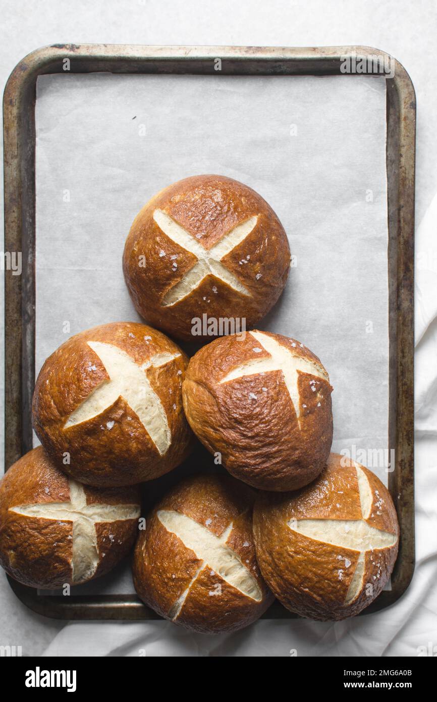 Top view of Pretzel buns on a parchment lined baking sheet, German ...