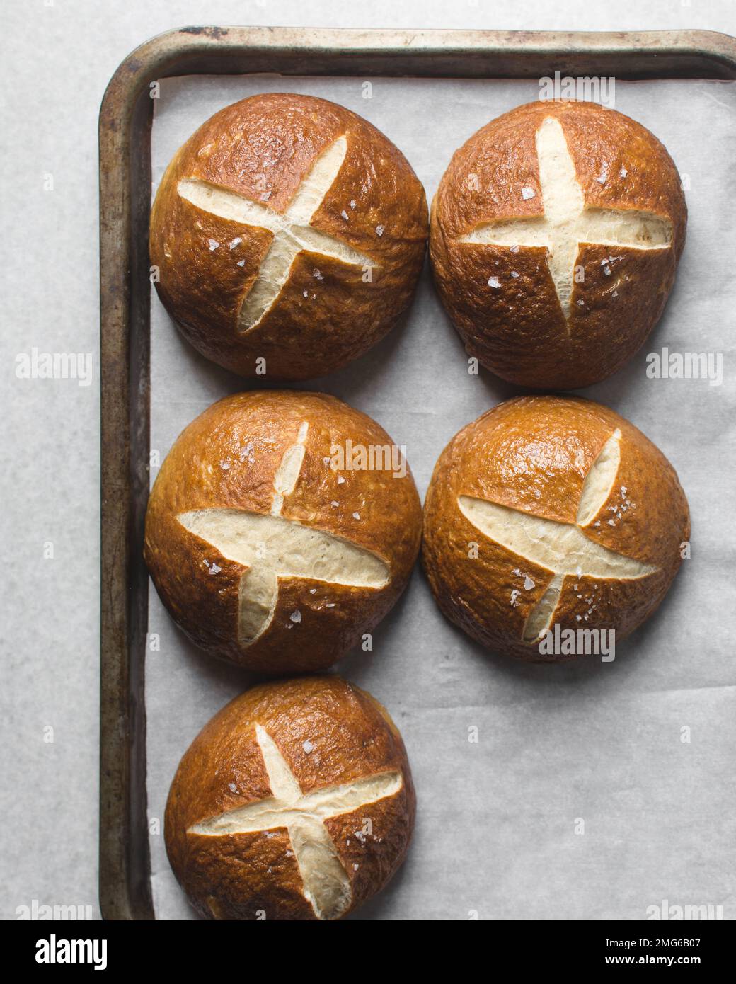 Top view of Pretzel buns on a parchment lined baking sheet, German ...