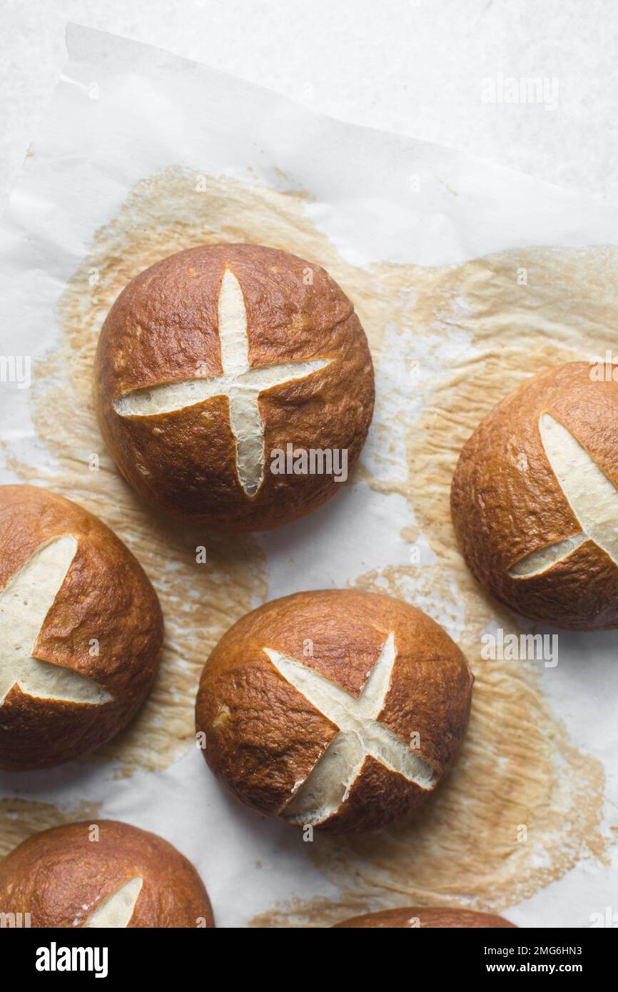 Top view of Pretzel buns on a parchment lined baking sheet, German ...