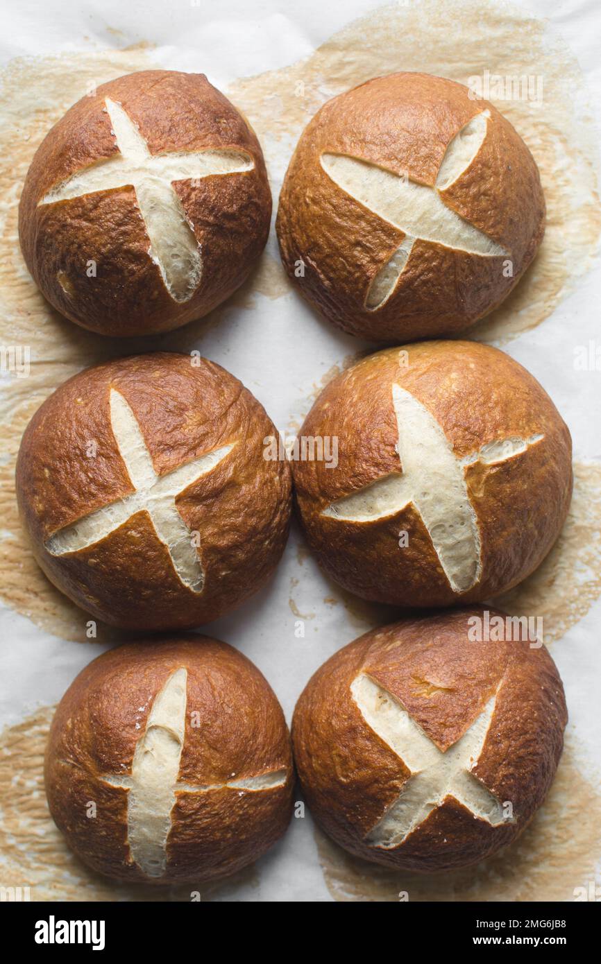 Top view of Pretzel buns on a parchment lined baking sheet, German ...