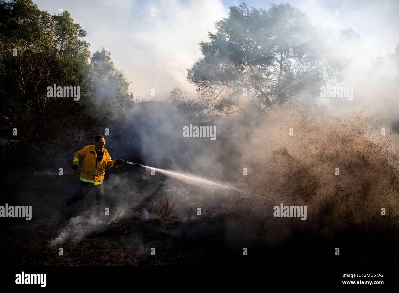 A firefighters attempts to extinguish a fire started by an incendiary ...