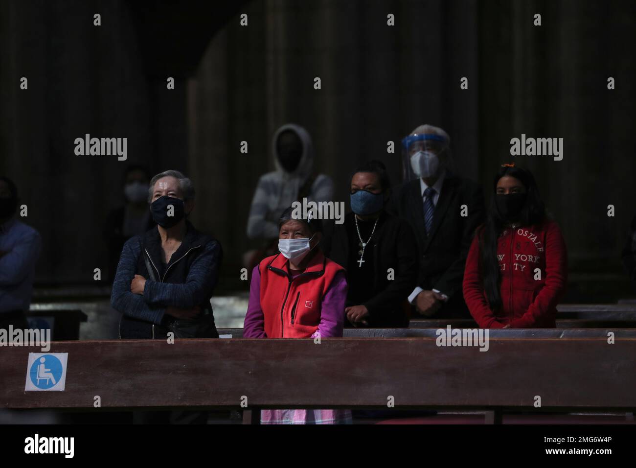 Parishioners wearing masks and face shields to curb the spread of the ...