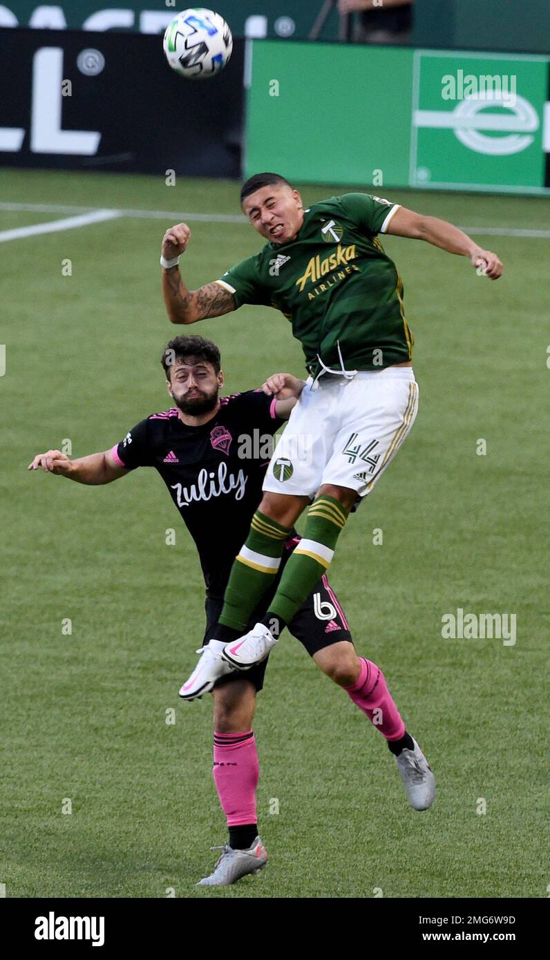 Portland Timbers midfielder Marvin Loria, right, goes up for the ball ...