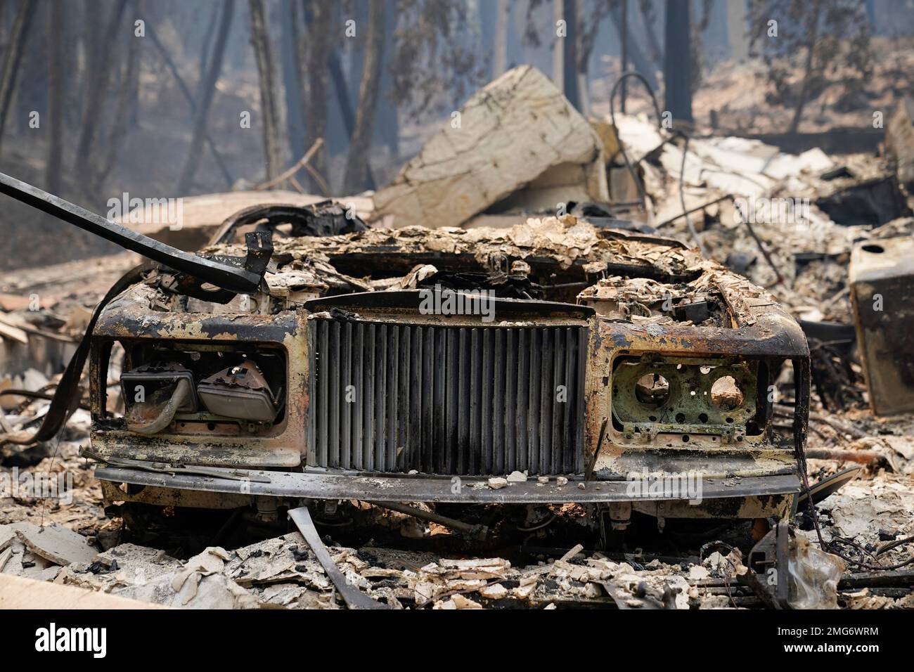 A charred vehicle is parked in front of a home after the CZU Lightning ...