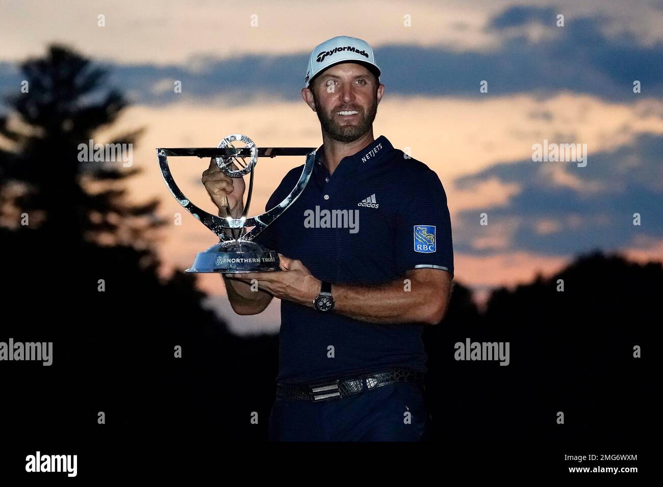 Dustin Johnson holds the trophy after winning the Northern Trust golf ...