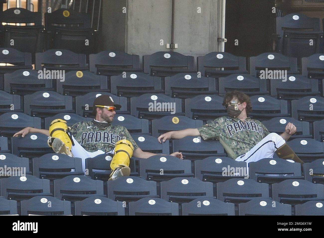 San Diego Padres players sit in the outfield stands during the seventh ...