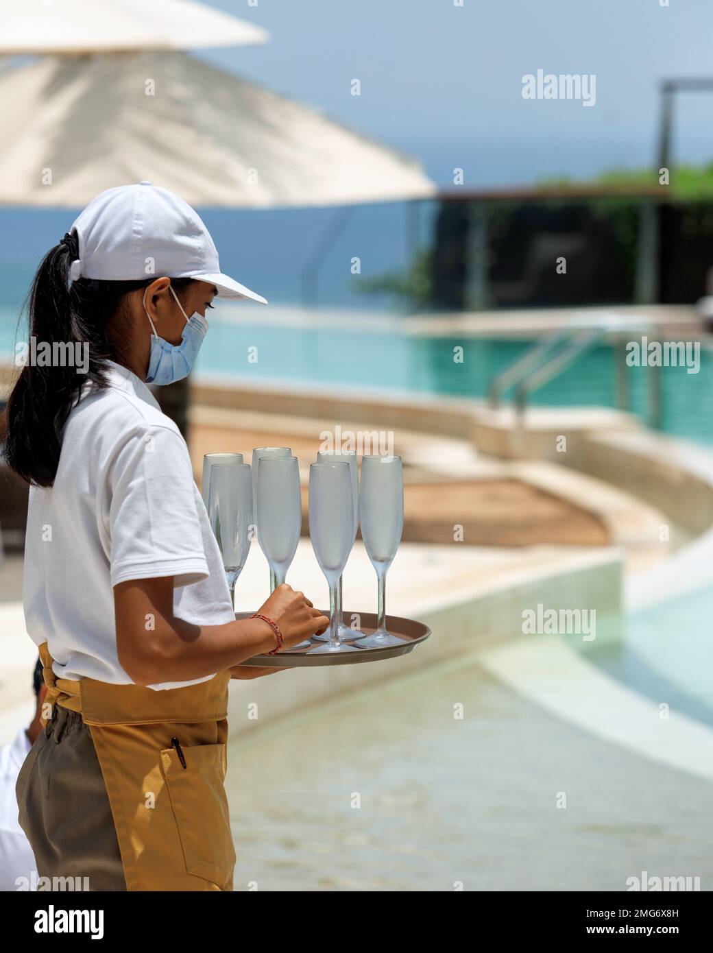 the waitress carries glasses. bali Stock Photo - Alamy