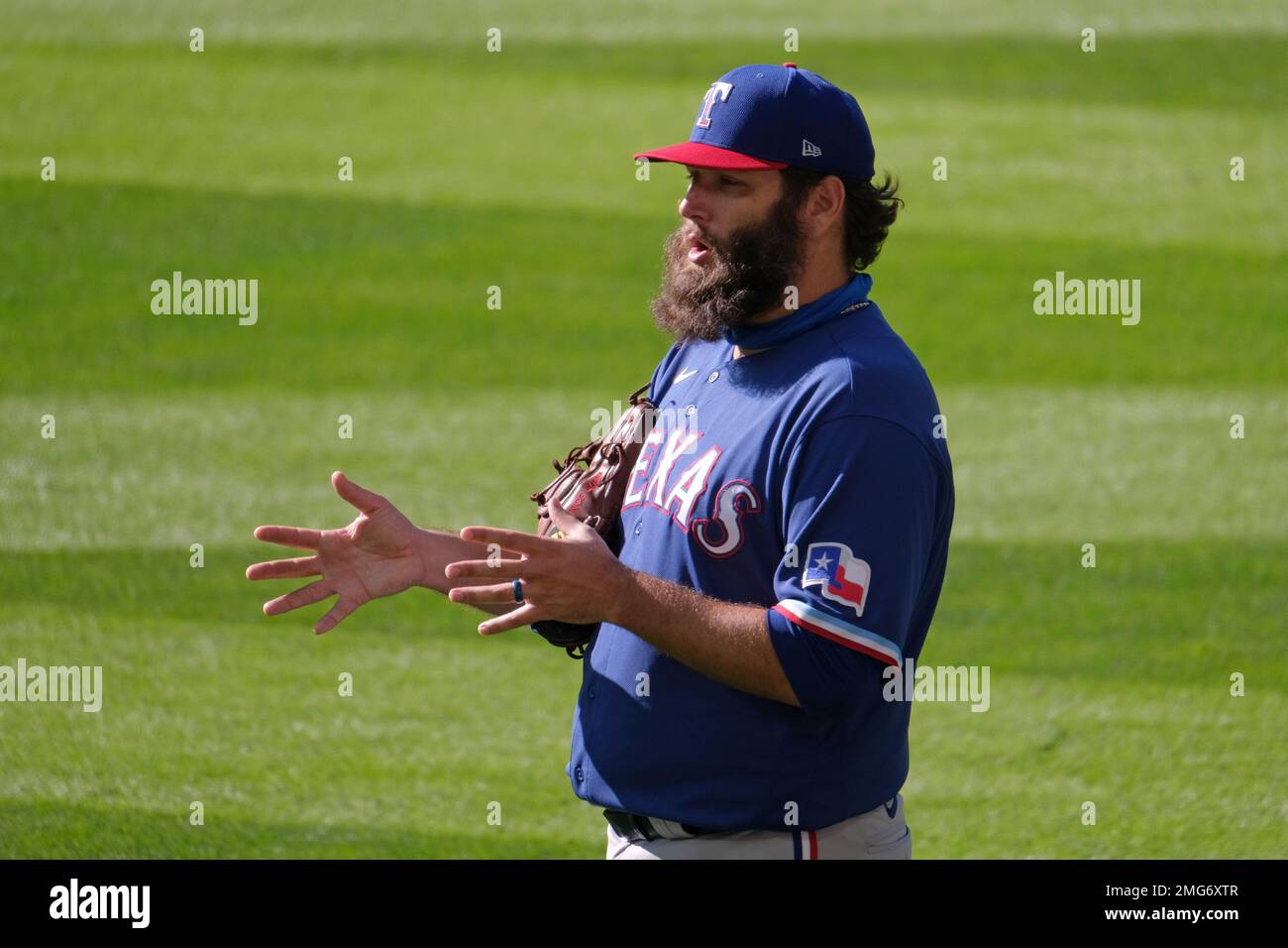 Texas Rangers pitcher Lance Lynn stands in the outfield and talks with ...