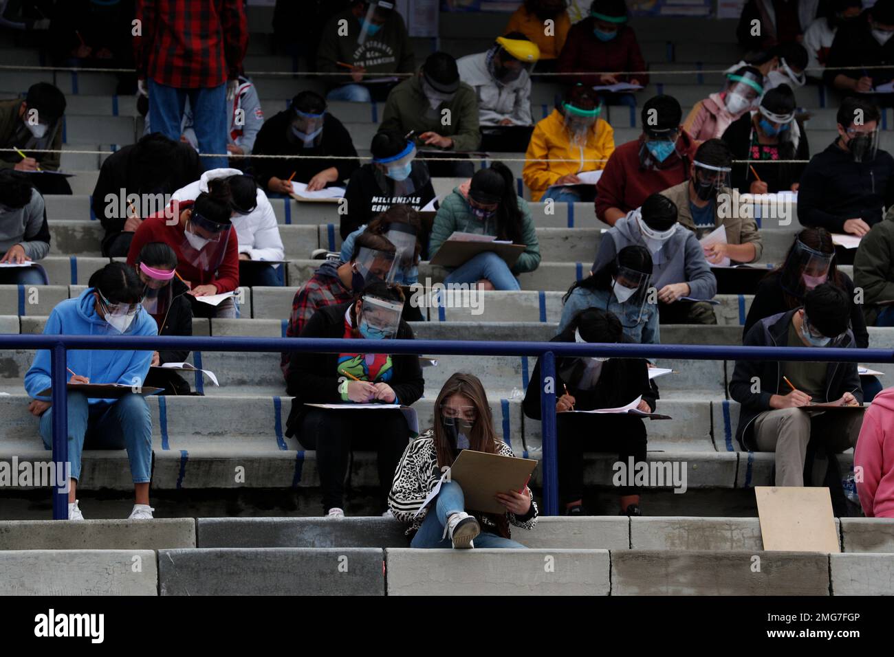 Prospective students wear face masks and shields as they take the ...