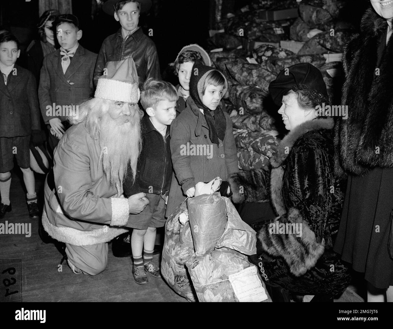 First lady Eleanor Roosevelt, right, helped Santa Claus distribute bags ...