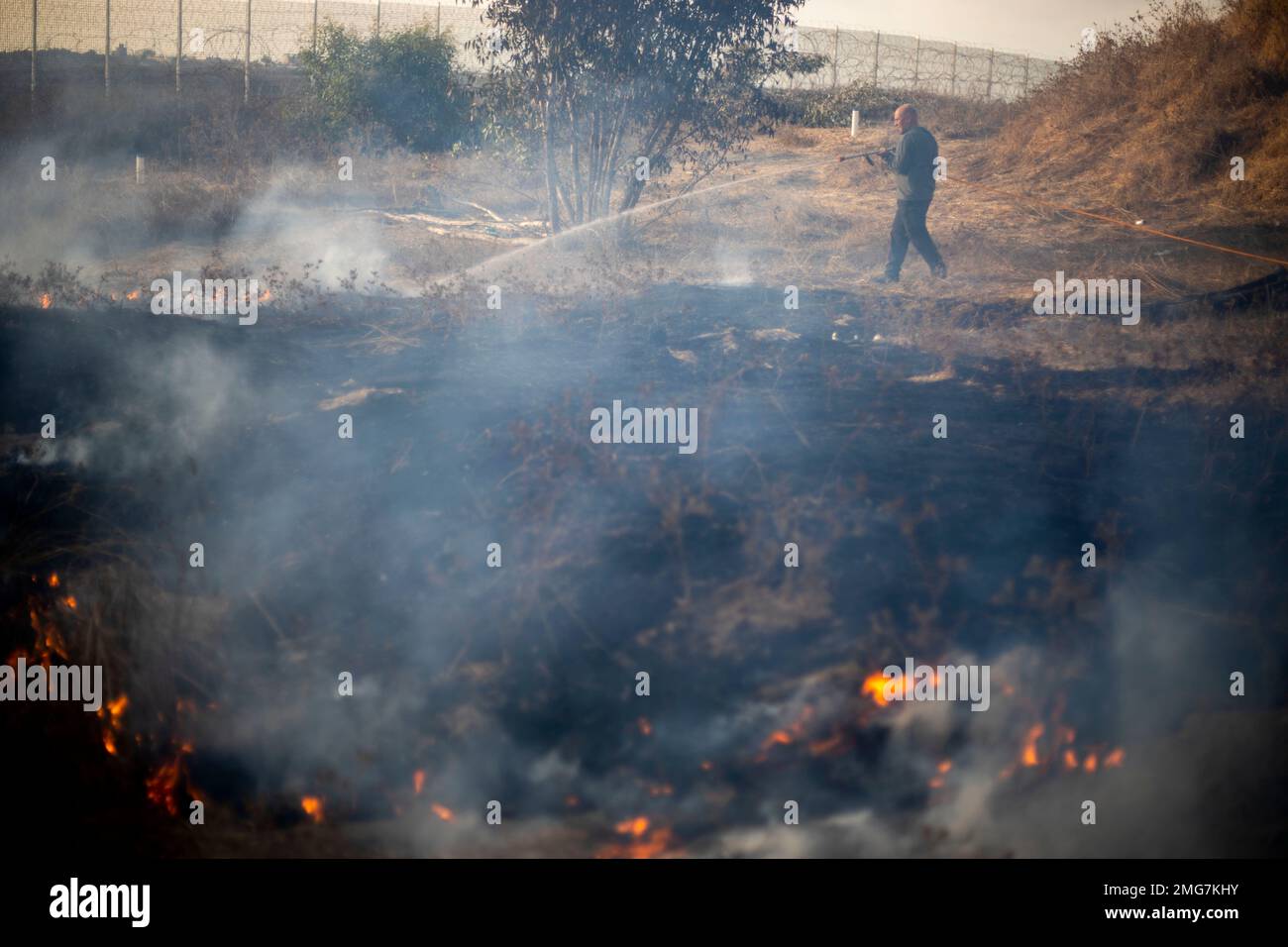 A volunteer attempts to extinguish a fire started by an incendiary ...