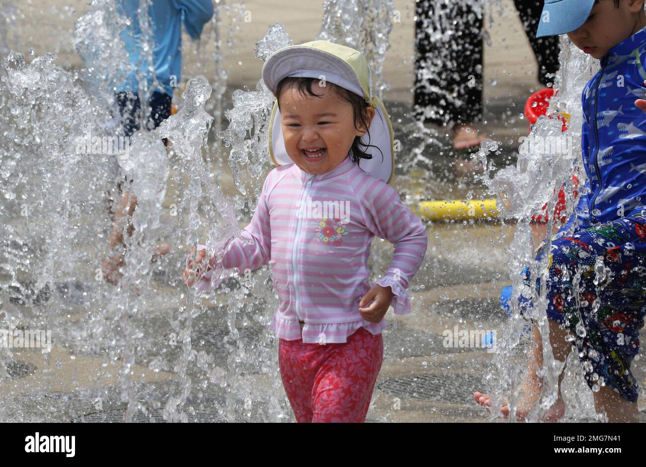 Children play in the water to cool off at a park in Yokohama, near ...