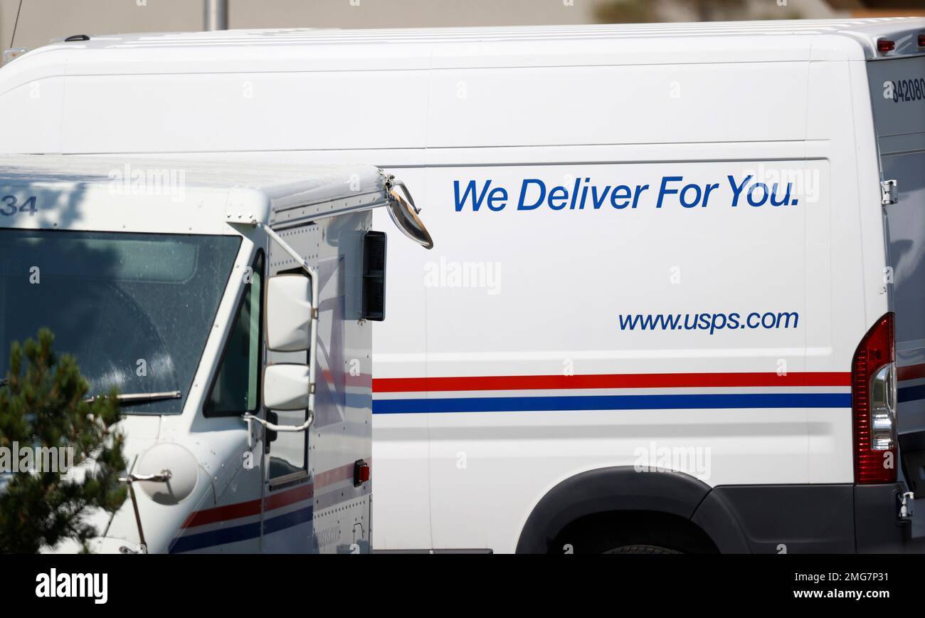 A United States Postal Service van heads out of a post office to make ...