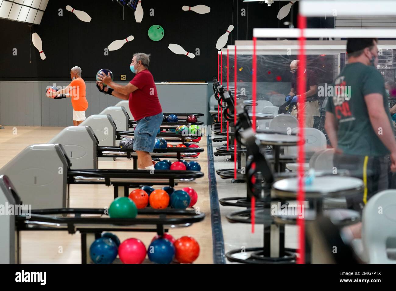 People separated by plexiglass barriers bowl at Homefield Bowl in ...