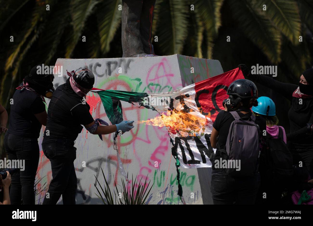 Demonstrators set fire to a Mexican flag with a sign that reads, in ...