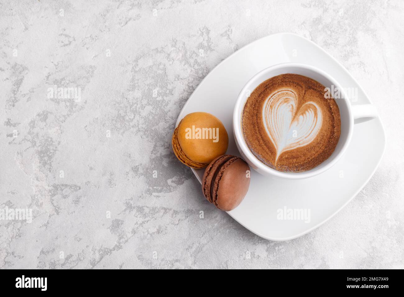 Cup of coffee and two macarons on the grey stone background with copy ...