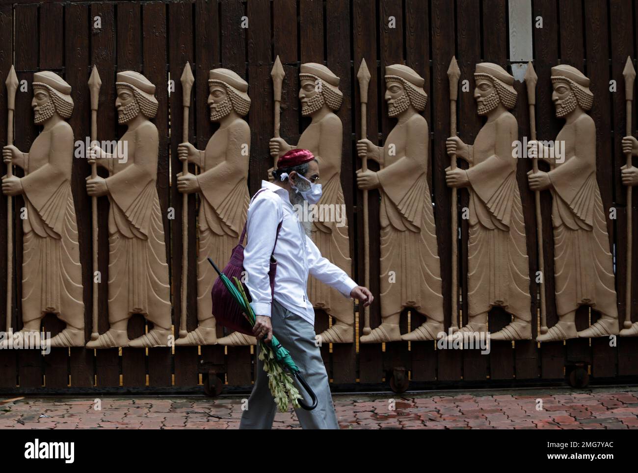A Parsi man wearing mask as a precaution against the coronavirus walks ...