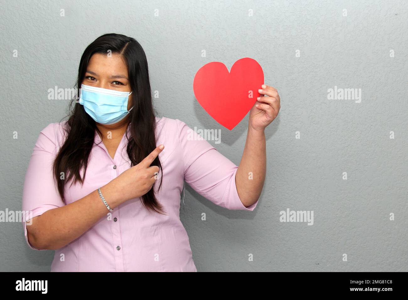 latin woman with protection mask clinical use and red heart, valentine ...