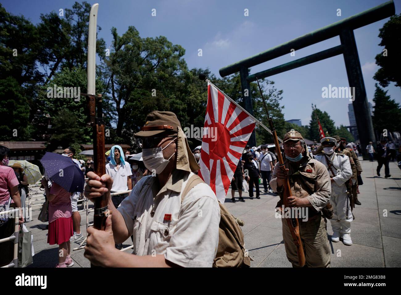 Visitors in Japanese Imperial army and navy uniforms stand at attention ...