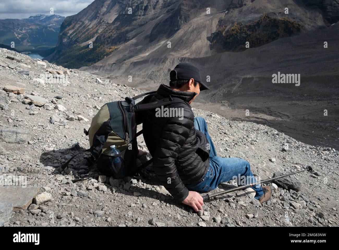 Tourist climbing down the steep slope of loose rocks on Plain of Six ...
