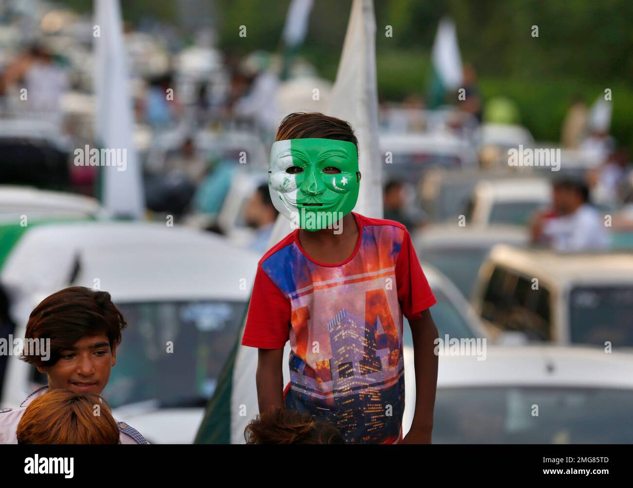 A boy wears a mask painted with color of nation flag while with others ...