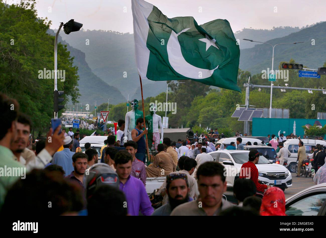 People hold national flags and march on a road to celebrate ...