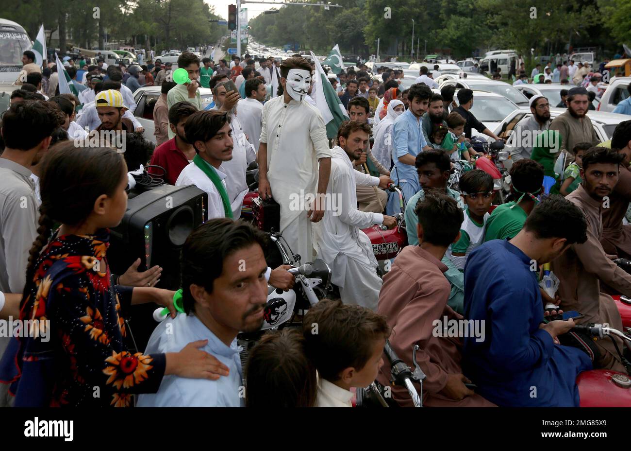 People hold national flags and march on a road to celebrate ...