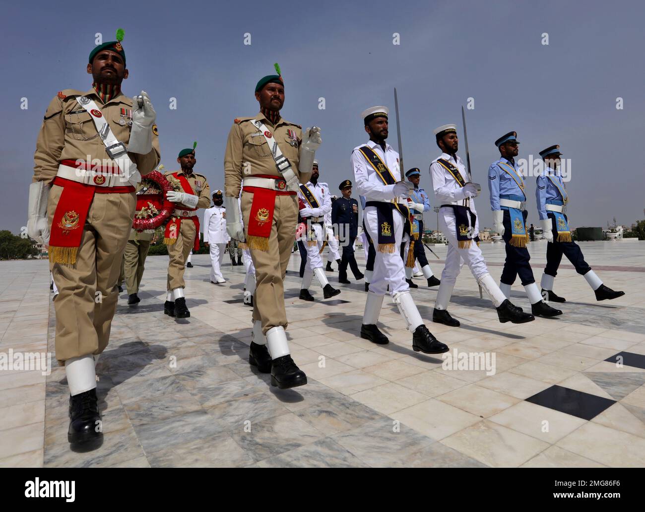 Pakistani troops march in formation during a ceremony at the mausoleum ...