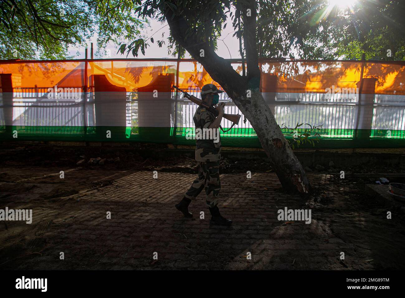 An Indian paramilitary soldier wearing a face mask patrols at the site ...