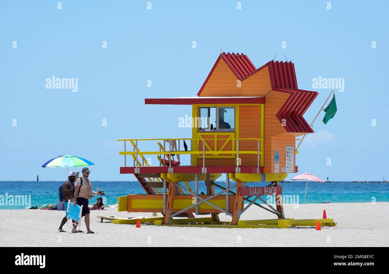 Beach goers walk past one of the lifeguard towers designed by architect ...