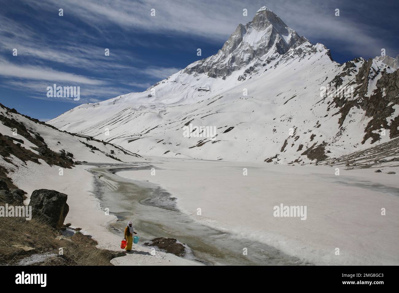 Mouni Baba, a Hindu holy man, fetches water from a stream at the feet ...