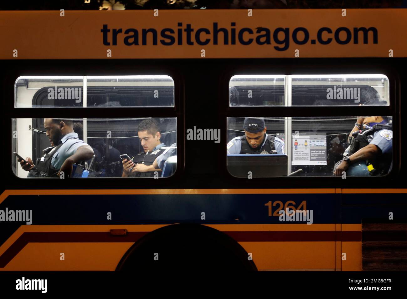 Chicago police officers wait on a transit bus Monday, Aug. 10, 2020 ...