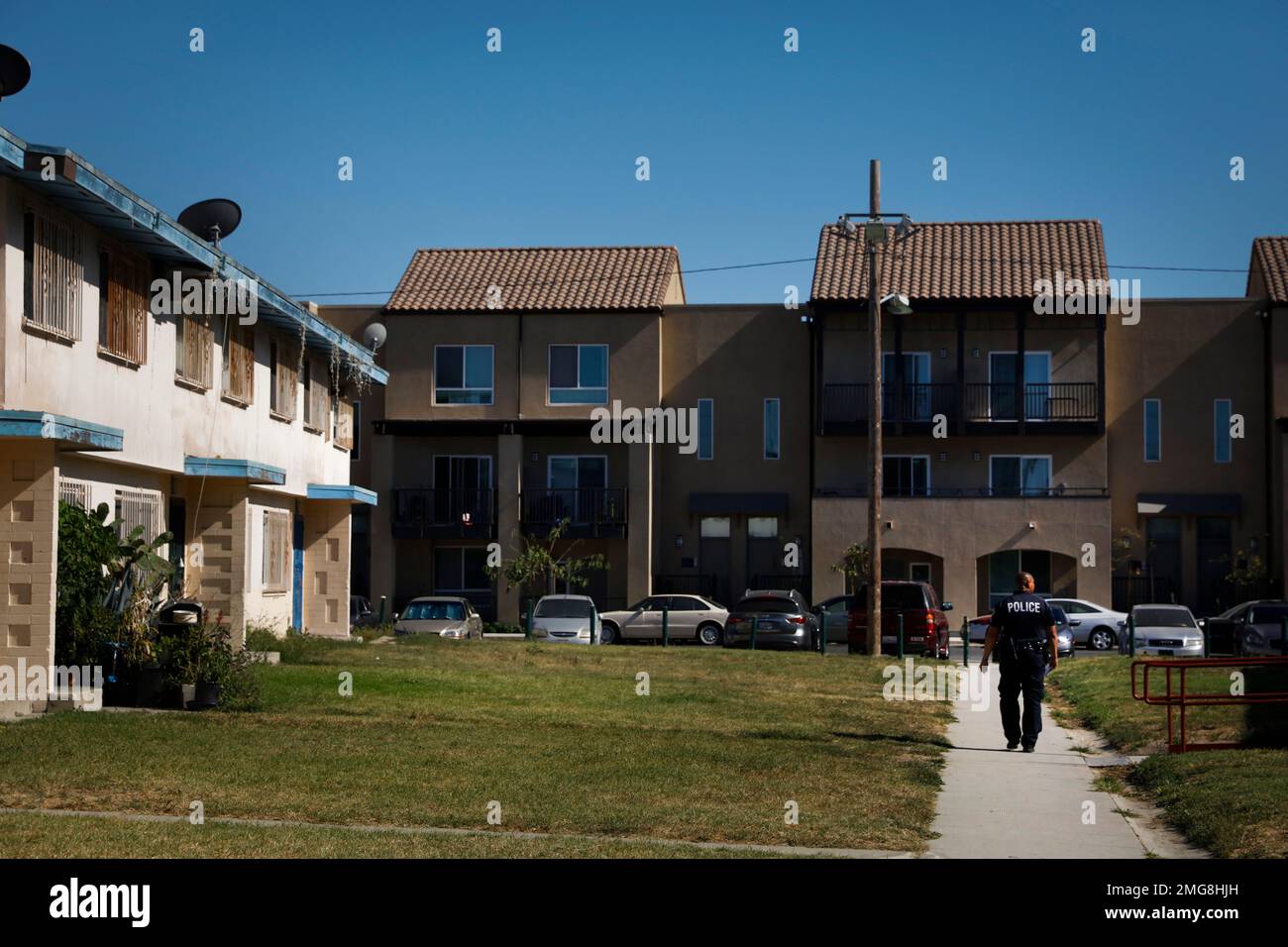 A police officer walks toward newly constructed apartment buildings at ...