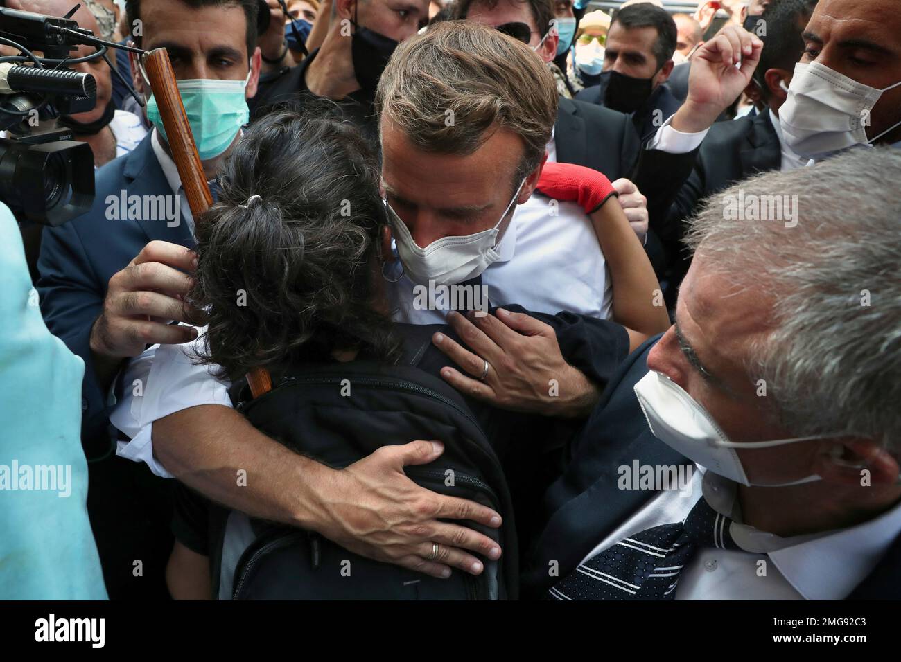 French President Emmanuel Macron, hugs a woman as he visits the ...