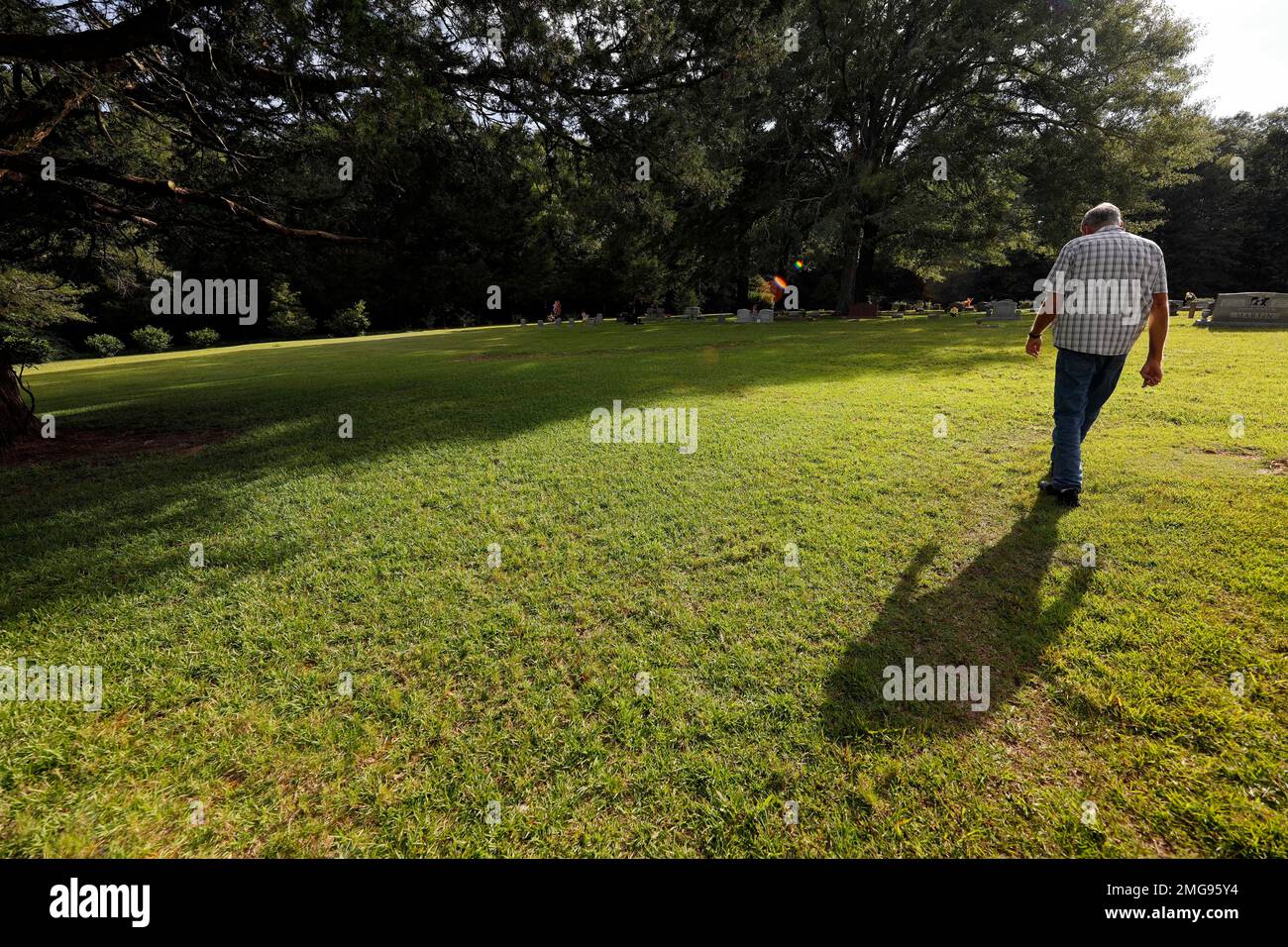 Father Bob Goodyear strolls across the center section of the cemetery ...