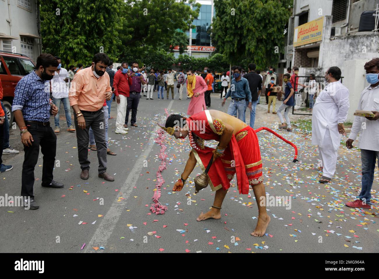 A man dressed as Hindu god Hanuman lights firecrackers during a ...