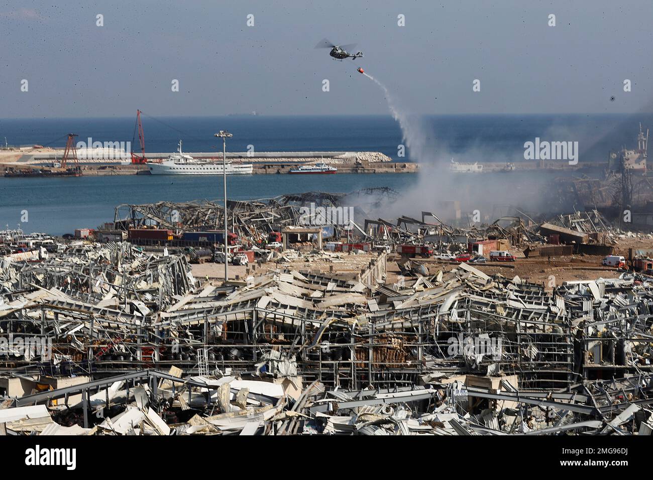 A Lebanese army helicopter throw water at the scene where an explosion ...