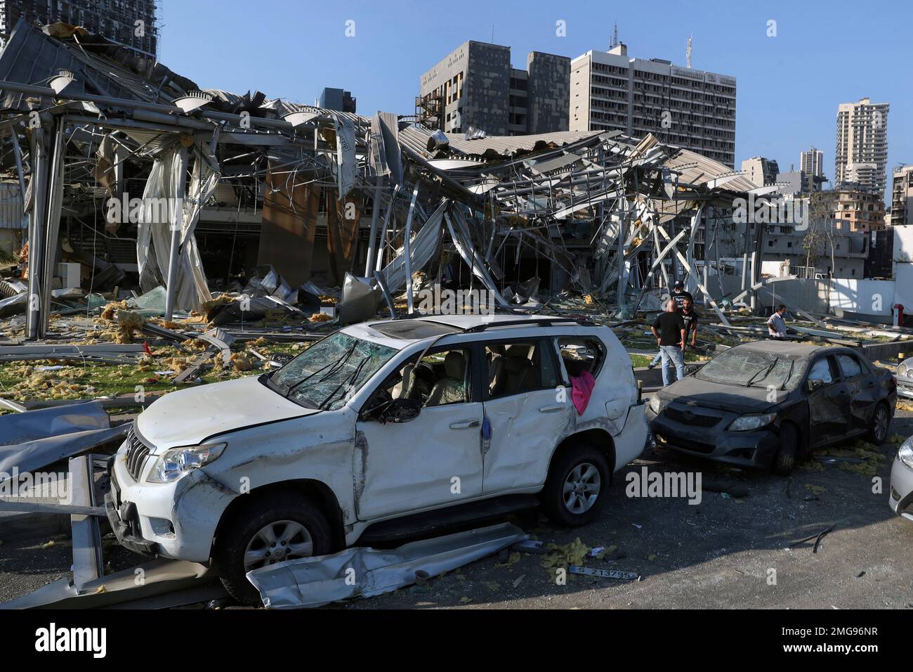 People inspect a destroyed building near the scene of an explosion that ...