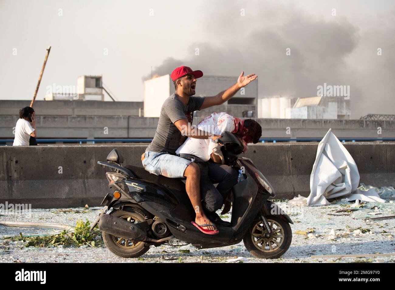 A man evacuates an injured person after a massive explosion in Beirut ...