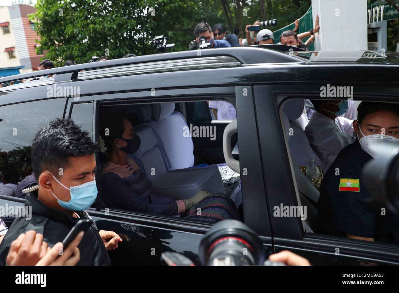 Myanmar leader Aung San Suu Kyi, back, sits inside a vehicle upon ...