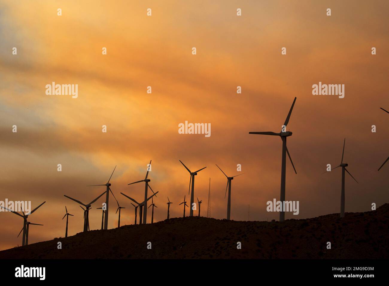 Smoke rise behind windmills from the Apple Fire during the sunset near ...