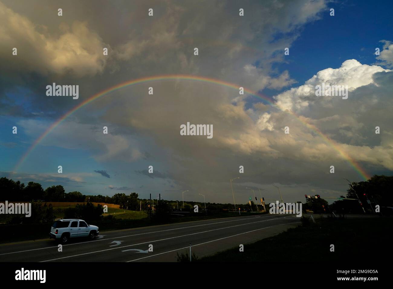 A rainbow stretches across an intersection after a shower passed ...
