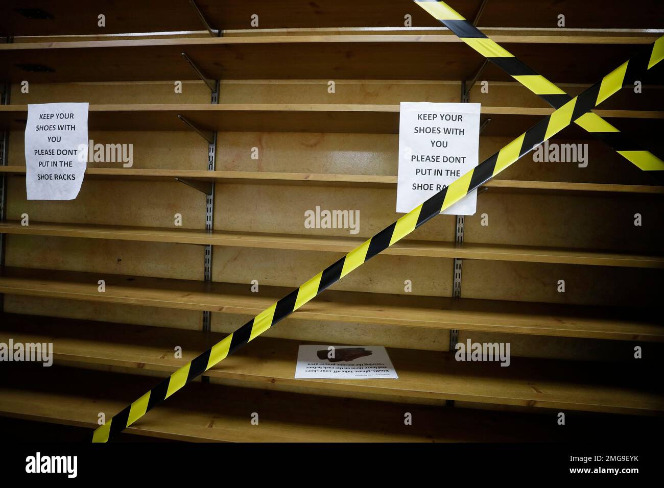 The shoe rack is taped off for safety measures at Minhaj-ul-Quran ...